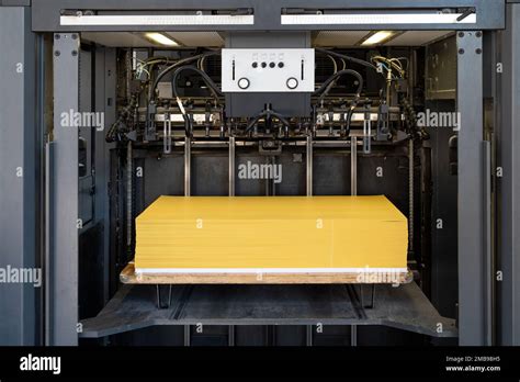 Modern Industrial Printer With Stack Of Yellow Sheets In Factory For Manufacturing And