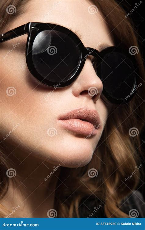 Красивая девушка в темных солнечных очках с скручиваемостями и составом вечера Сторона красотки