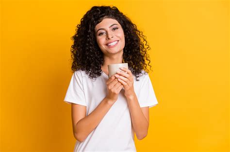 생생한 노란색 배경에 고립 된 미소 휴식에 곱슬 갈색 머리 마시는 차의 사진 초상화 T 셔츠에 대한 스톡 사진 및 기타 이미지 T 셔츠 갈색 머리 곱슬 머리 Istock