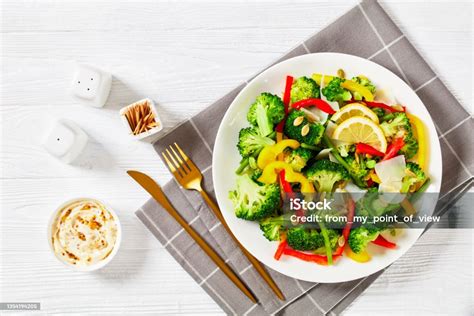 브로콜리 스위트 페퍼 그린 콩 샐러드에 해바라기 씨와 면도파마산 치즈를 나무 테이블에 흰색 접시에 얹고 위에서 수평으로 바라보며 평평한 평지 0명에 대한 스톡 사진 및 기타