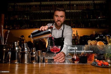 바텐더가 칵테일을 쏟아 붓는 다양한 바 장비와 잔이있는 바 카운터의 장엄한 전망 바텐더에 대한 스톡 사진 및 기타 이미지 바텐더 마실 것 빨강 Istock