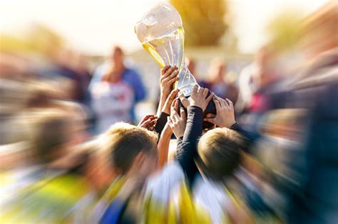 경기장에서 머리 위에 트로피 컵을 들고 있는 아이들 축구 축구 최종 토너먼트 경기에서 우승한 후 골든 컵을 오르는 행복한 소년 그룹 청소년 대회에서 스포츠 성공을 위해