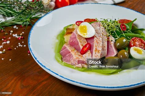 나무 배경에 흰색 접시에 신선한 중간 희귀 구운 참치 케이퍼 체리 토마토 아스파라거스와 맛있는 식욕을 돋우는 샐러드에 대한 보기를 닫습니다 0명에 대한 스톡 사진 및 기타