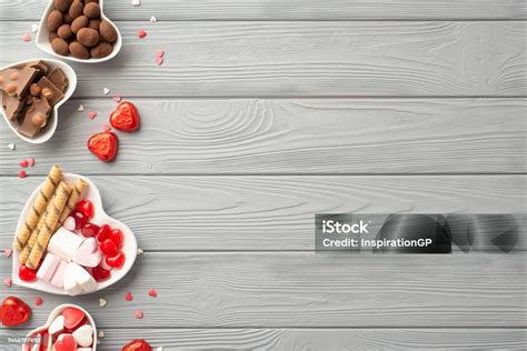 발렌타인 데이 개념입니다 과자 초콜릿 젤리 사탕 쿠키와 색종이가 있는 하트 모양의 식기의 상위 뷰 사진 복사 공간이 있는 회색 나무 책상 배경 0명에 대한 스톡 사진 및