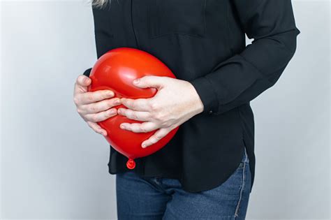 팽만감 과 자만심 개념 여자는 복부 근처에 빨간 풍선을 들고 이는 Bloating을 상징한다 장 내 및 소화 시스템 자만심과 위장관 문제 가까운에 대한 스톡 사진 및 기타