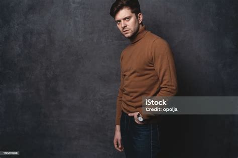 카메라를보고 회색 배경에 잘 생긴 젊은 남자 회색 벽에 기대어 주머니에 손을 가진 젊은 남자의 초상화 긍정적인 감정 표현에 대한 스톡 사진 및 기타 이미지 Istock