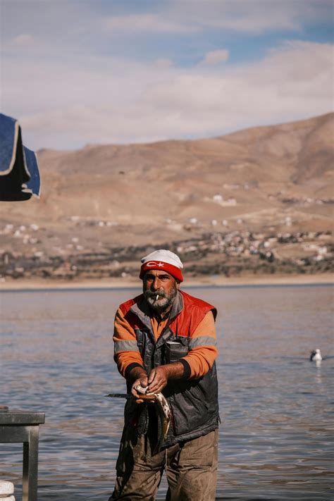 산 호수 옆에서 물고기를 잡은 어부 · 무료 스톡 사진