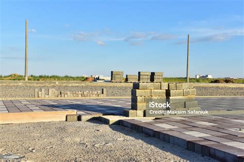 건설 현장에서 포장 슬래브를 누워 마을 보행자 구역에 포장 벽돌을 설치하는 과정 콘크리트 블록을 설치하기 위해 모래를 규준 도로 공사 포장 개조 공사 0명에 대한 스톡 사진