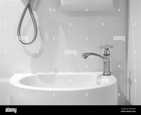 White Clean Bathroom Interior With Simple Chrome Faucet On Empty Sink Basin On White Wall