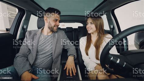 사랑 하는 남편 좋은 인테리어와 가죽 시트와 새로운 자동차 안에 앉아있는 동안 그의 행복 한 아내에 게 차 키를 주고 있다