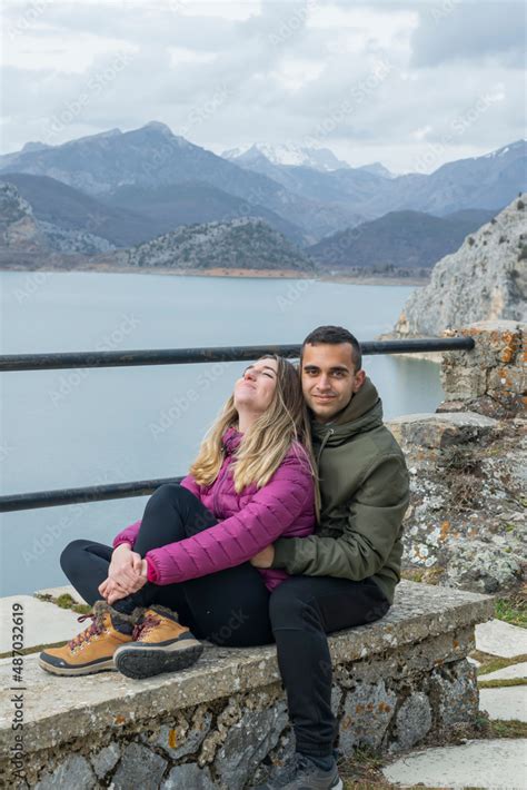 Pareja Joven Enamorada Sentada Y Abrazada En Un Banco Con Las Monta As Nevadas De Fondo Foto De