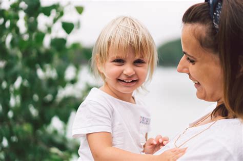 어린 어머니가 아기를 안고 있습니다 어머니와 어린 딸은 자연속에서 즐거운 시간을 보내고 있습니다 어머니의 날 2명에 대한 스톡