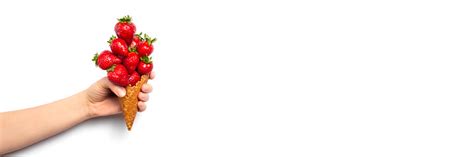 흰색 배경에 고립 된 잘 익은 딸기로 가득 찬 아이스크림 콘 잘 익은 딸기와 와플 콘을 들고 있는 여성의 손 복사 공간이 있는