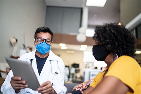 집에서 수석 환자를 방문하는 디지털 태블릿을 사용하는 의사 얼굴 마스크를 착용 2명에 대한 스톡 사진 및 기타 이미지 2명