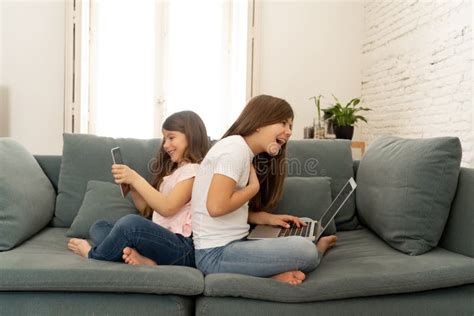 Two Pretty Sisters Having Fun Together Playing And Surfing On Th Stock