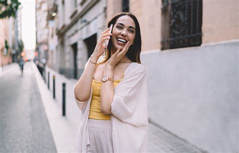 로밍 인터넷 연결에 만족하는 도시 거리에서 웃는 얼굴에 완벽한 솔직한 미소를 짓는 이빨 힙스터 소녀 재미있는 여성 관광객이