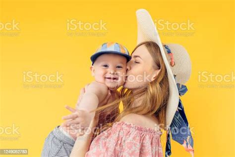 노란 배경에 어린 소년을 들고 여름 모자에 행복한 젊은 어머니 여름 방학 가족에 대한 스톡 사진 및 기타 이미지 가족
