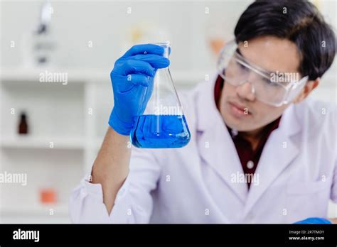 Young Asian Scientist Man Wearing White Lab Uniform Testing Research Medical Formula At