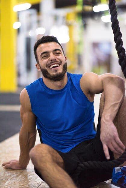 Premium Photo Young Muscular Man Sitting And Relaxing Before Rope Climbing In Cross Fitness Gym