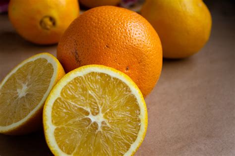 육즙이 많은 잘 익은 오렌지를 반으로 자르고 밝은 갈색 배경에 오렌지를 흩뿌린다 0명에 대한 스톡 사진 및 기타 이미지 0명 감귤류 과일 건강한 식생활 Istock