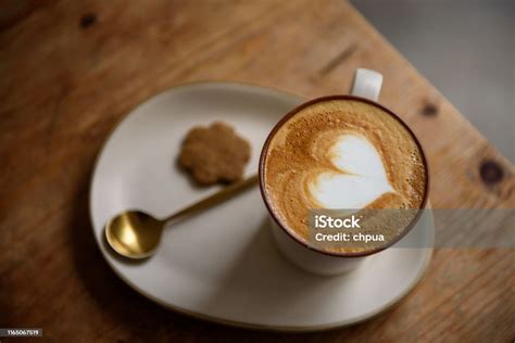 나무 테이블에 비스킷과 숟가락을 곁들인 러브 셰이프 라떼 아트 커피 0명에 대한 스톡 사진 및 기타 이미지 0명 갈색