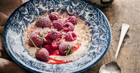 라즈베리를 곁들인 요구르트 한 그릇과 차 한 잔 사진 Unsplash의 푸드 스타일링 이미지