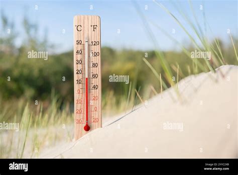 Wooden Celsius And Fahrenheit Scale Thermometer In The Sand Ambient
