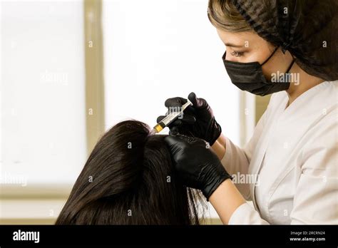 Сosmetologist uses thin needle to inject Platelet Rich Plasma in scalp PRP therapy and plasma