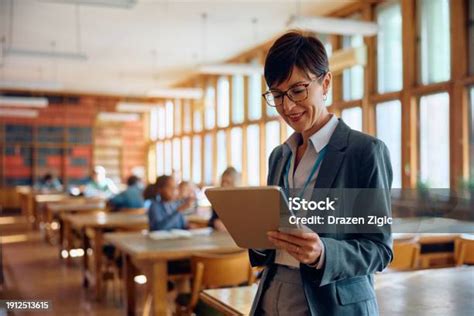 교실에서 디지털 태블릿을 사용하는 행복한 고등학교 교사 교사 교육 관련 직업에 대한 스톡 사진 및 기타 이미지 교사 교육 관련 직업 교육 태블릿 Istock
