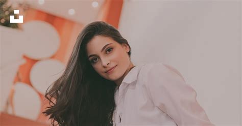 흰 셔츠와 검은 바지를 입고 사진을 찍기 위해 포즈를 취하는 여성 사진 Unsplash의 무료 회색 이미지