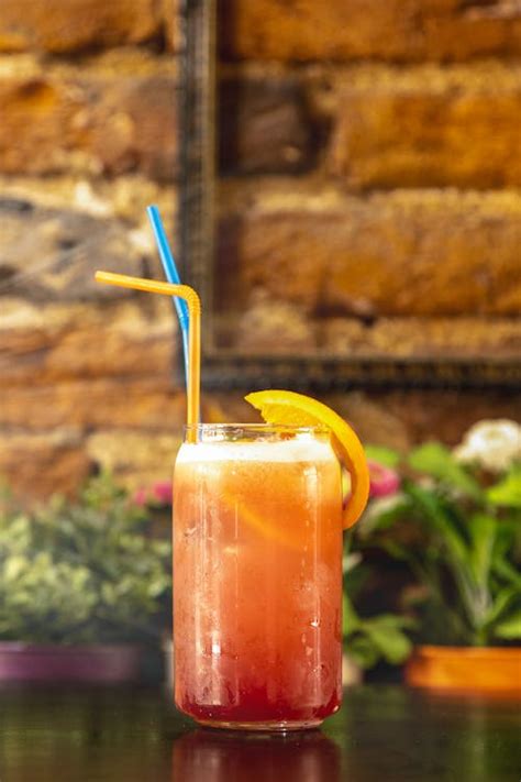 오렌지 주스와 투명 유리 발 유리 · 무료 스톡 사진