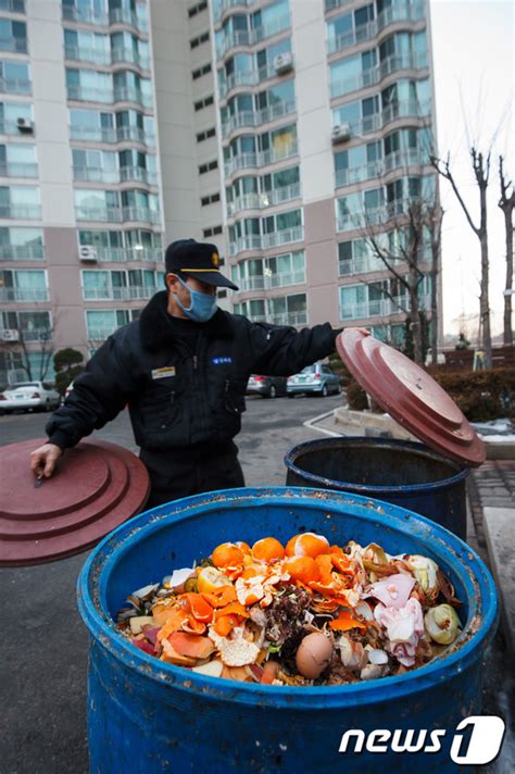 사진 가득 찬 음식물쓰레기통 정리하는 경비원