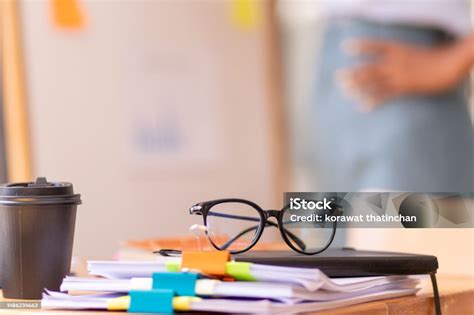 사업가와의 회의에서 올바른 문서를 사용하기 위해 이사회에 보내기 전에 테이블에 쌓인 문서를 검색하고 검토하기 위해 종이 문서 더미에서 작업하는 여성 사업가 A4 용지에 대한