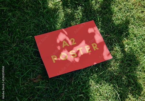 Horizontal A2 Poster Mockup Over Green Grass With Sunlight Shadows