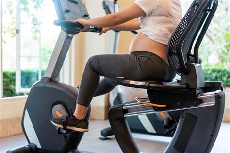 요가룸의 피트니스 센터에서 활동적인 임산부 운동을 합니다 임신 한 배에 아기를 들고 젊은 기대 어머니 출산 전 관리 및 여성 임신 개념 건강관리와 의술에 대한 스톡 사진 및