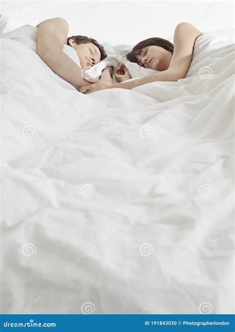 Молодые пары спать в кровати Стоковое Фото изображение насчитывающей закрыто спать 191843030