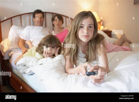 Adolescente Et Sa S Ur Avec Leurs Parents Couch Dans Le Lit En Regardant La T L Photo Stock