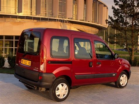 Small Red Van Parked In Front Of A Building