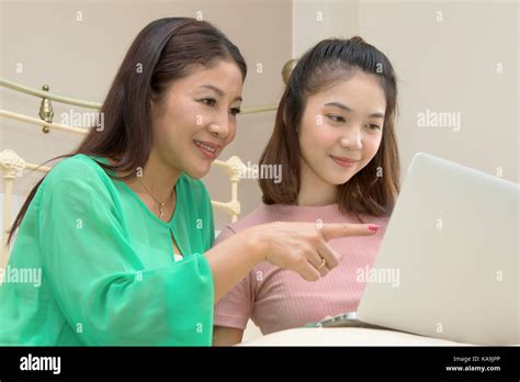 Asiatische Mutter Und Ihre Tochter Im Teenageralter Sind Mit Computer Beim Sitzen Auf Dem Bett