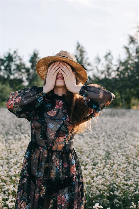 Woman In Floral Dress Among Flowers Hiding Face By Stocksy