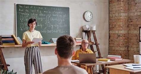 교실에서 수업 중에 교사와 급우에게 보고서를 발표하는 학생 사진 Unsplash의 선생 이미지