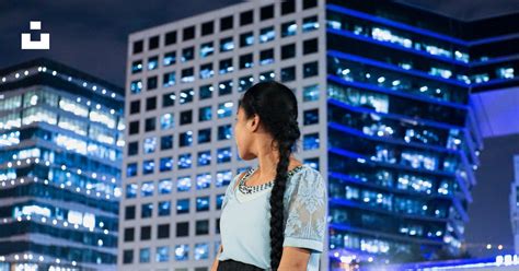 흰색과 검은색 티셔츠를 입은 여자가 밤 시간 동안 건물 근처에 서 있다 사진 Unsplash의 무료 필리핀 이미지