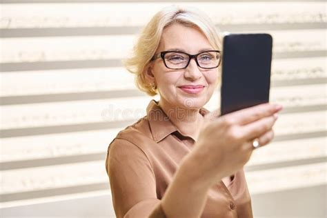 Lady In A Brown Blouse Takes Selfie Wearing New Glasses Stock Image
