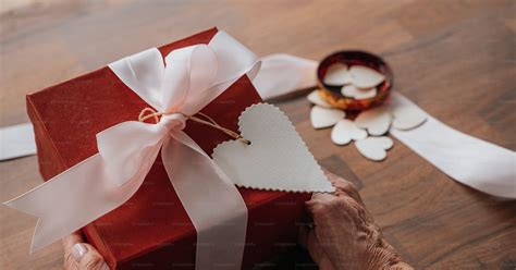 빨간색과 흰색 선물 상자를 들고 있는 사람 사진 Unsplash의 선물 제공 이미지