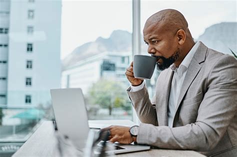 노트북을 사용하고 현대적인 사무실에서 커피를 마시는 성숙한 사업가의 샷 성년 남자에 대한 스톡 사진 및 기타 이미지 성년 남자 측면 보기 40 44세 Istock