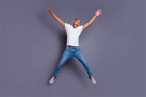 그의 그 좋은 잘생긴 매력적인 남성 왕성한 사람 재미 회색 보라색 퍼플 파스텔 배경 위에 고립 된 흰 셔츠 청바지를 입고의 전체 길이 몸 크기 초상화 점프에 대한 스톡 사진