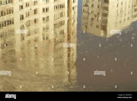 Building Is Reflected In Puddle Surface Of Water In City Reflection