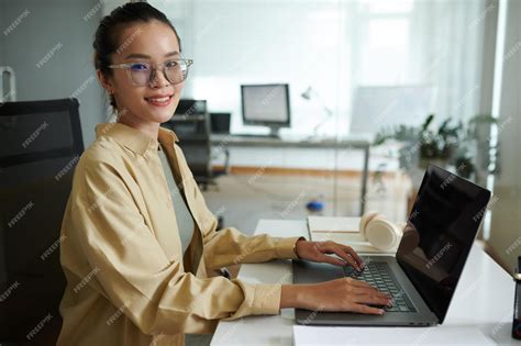 Premium Photo Portrait Of Smiling Programmer Working On Laptop At Her Office Desk