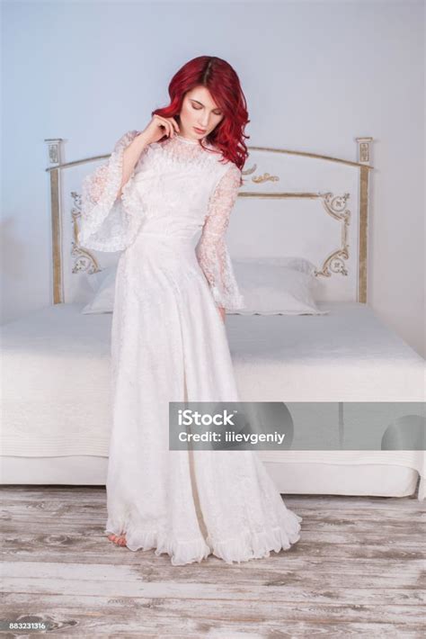 붉은 머리와 자연 스러운 메이크업과 창백한 피부와 아름 다운 여자 하얀 드레스 르네상스에 여자입니다 모델 스튜디오에서 포즈입니다 특이 한 모양입니다 침실에 신부 복고풍에