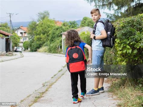학교로 돌아 가기 배낭을 메고 걷는 행복한 아이들 형제들은 여름 방학을 마치고 학교에 갑니다 남학생과 그의 남동생은 새 학년을